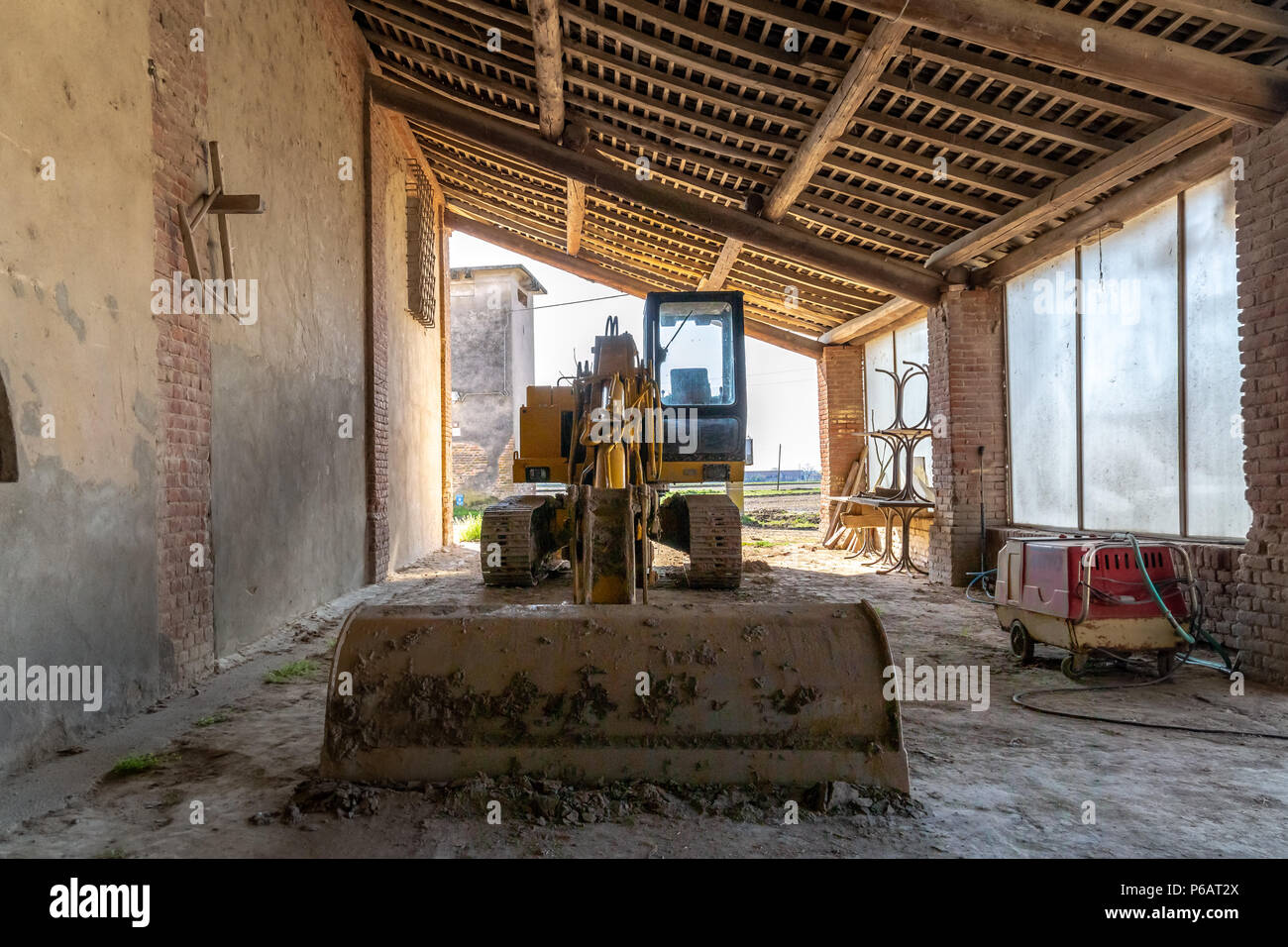 photograph of a bulldozer parked under a farm shed Stock Photo - Alamy