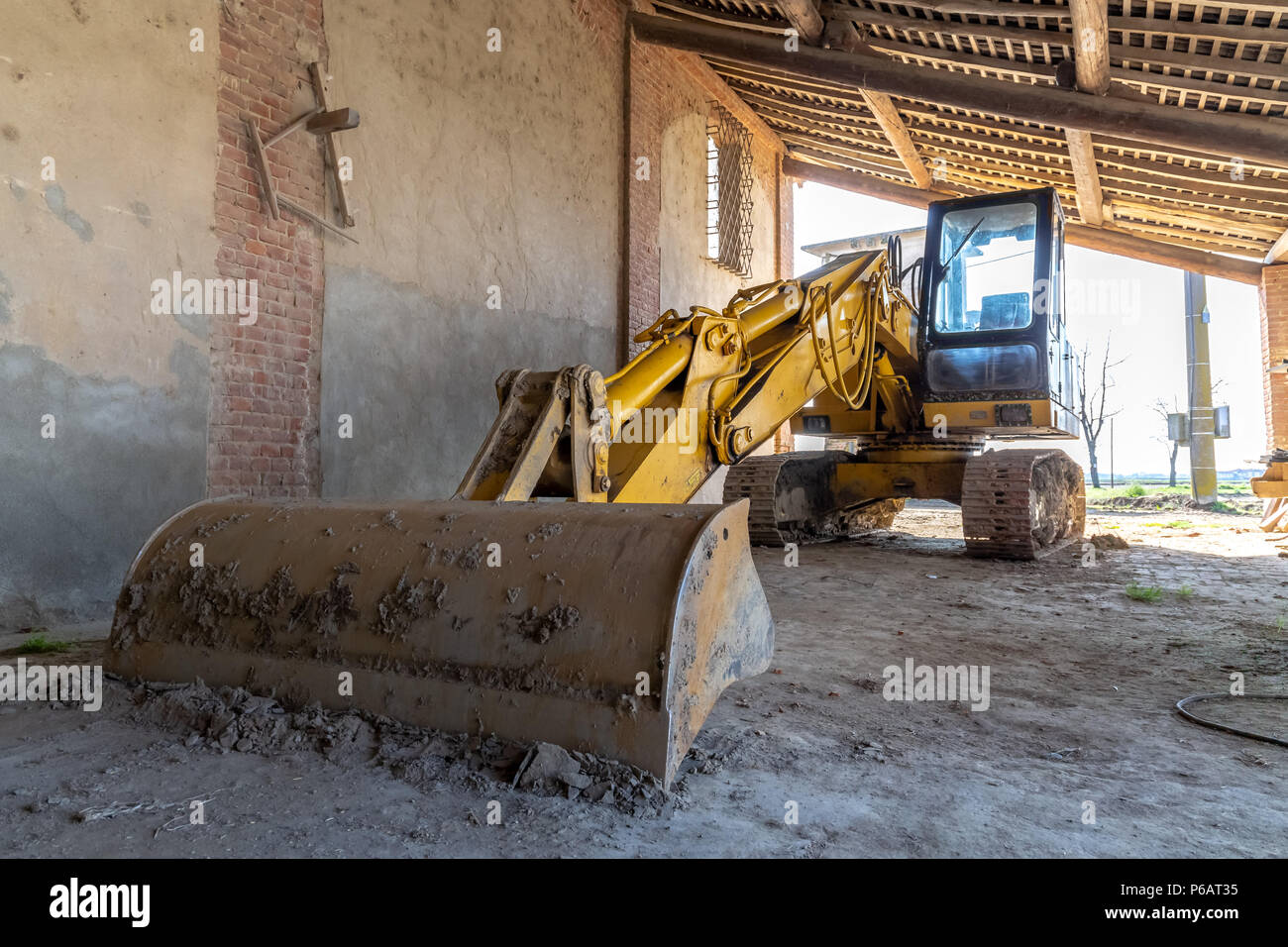 photograph of a bulldozer parked under a farm shed Stock Photo - Alamy
