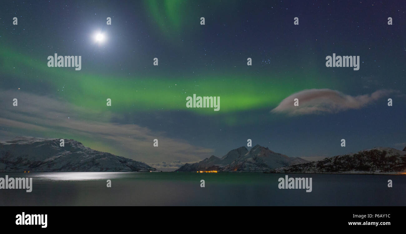 Moon shining over mountains with sky colored with green northern ligths ...