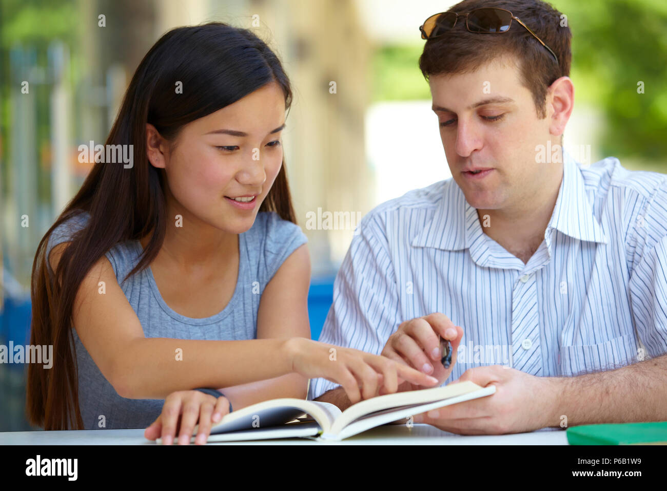 Caucasian male college students study together with asian female ...