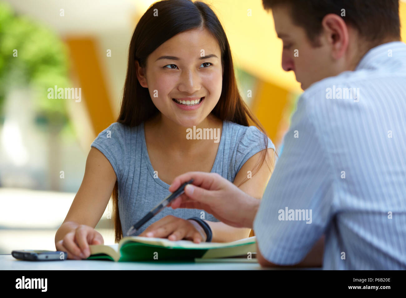 Caucasian male college students study together with asian female ...