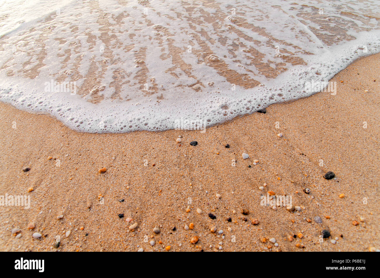 Small foam wave on sea close with beach Stock Photo - Alamy