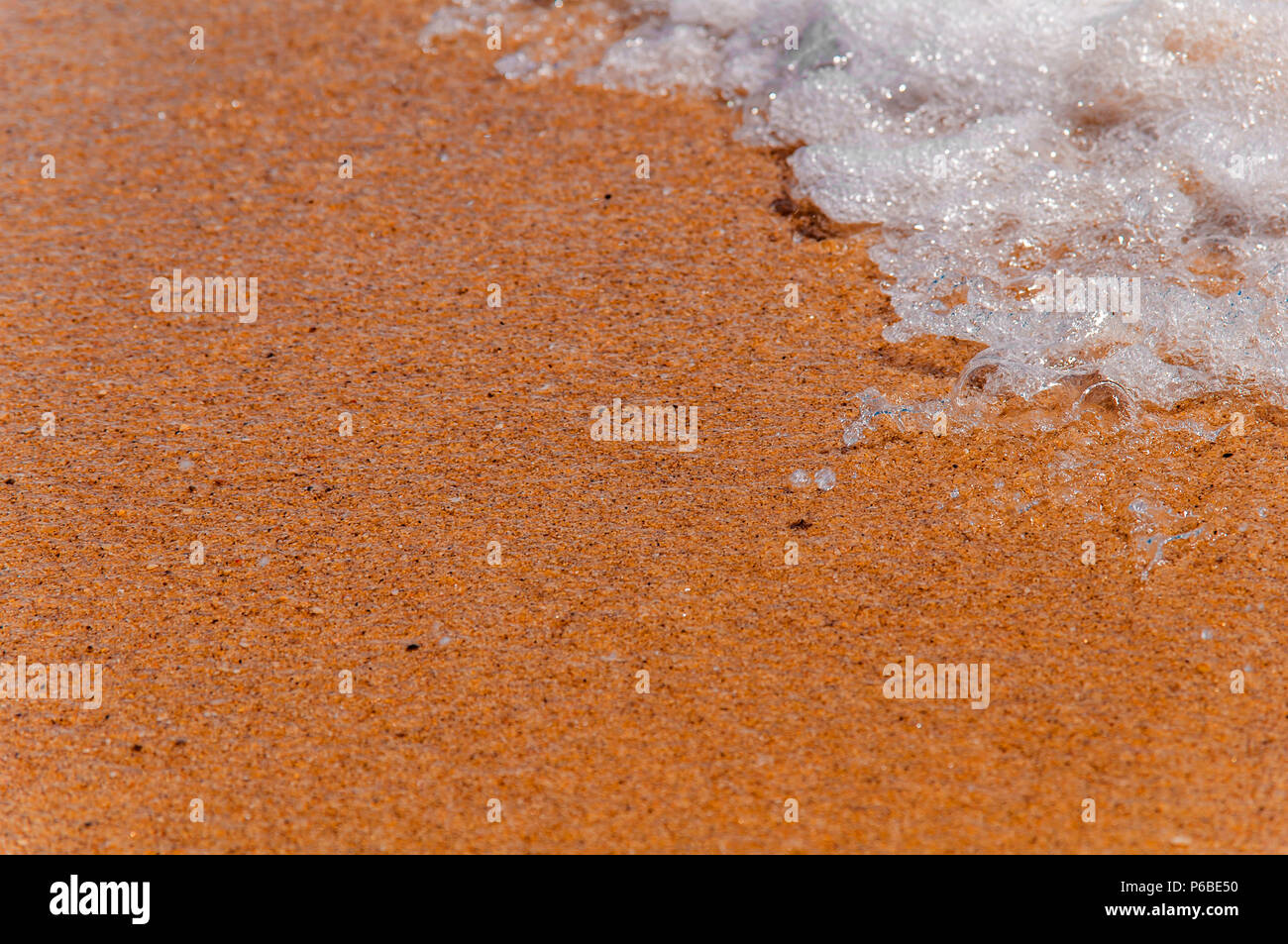 Small foam wave on sea close with beach Stock Photo - Alamy