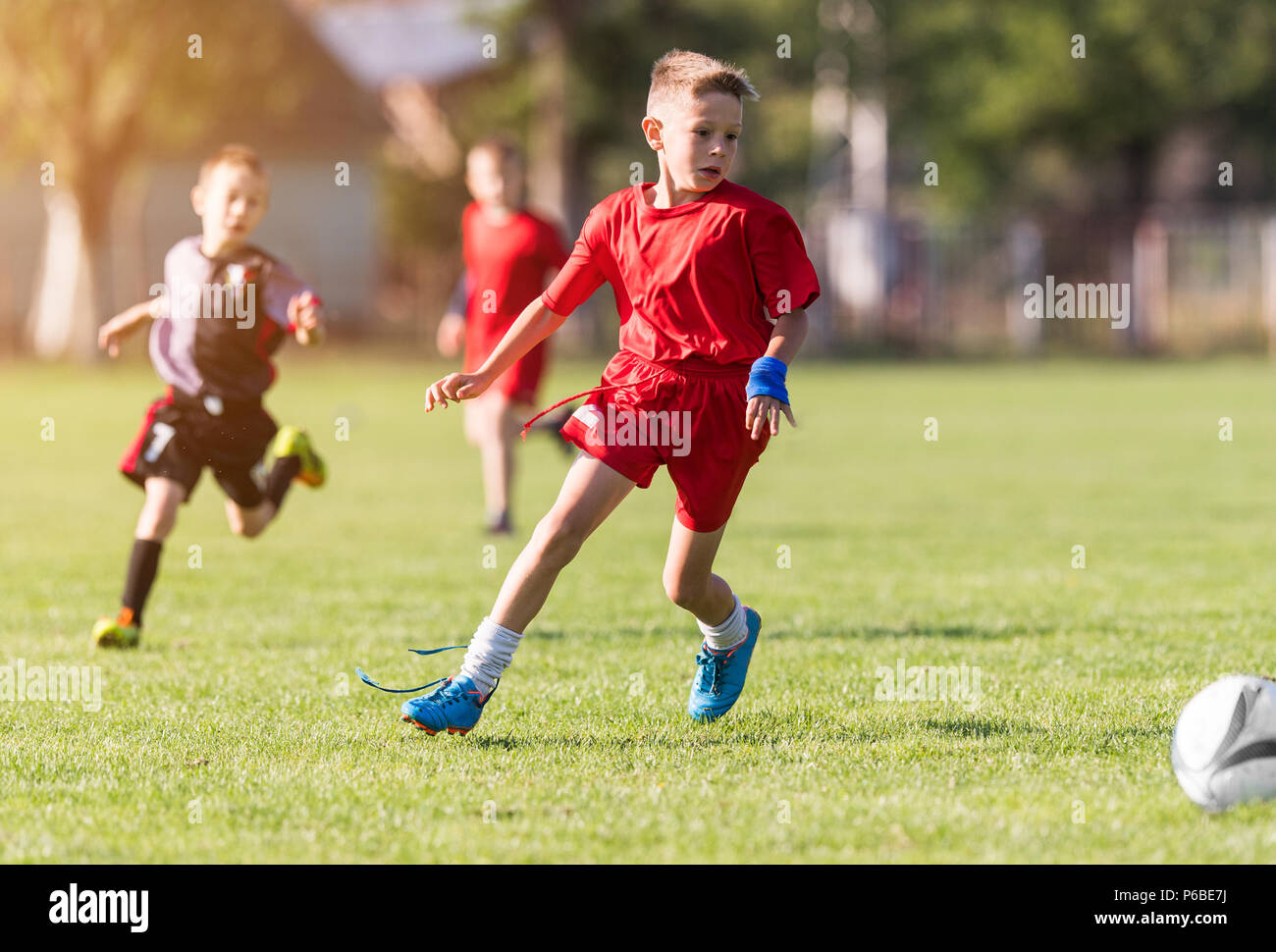 Boy kicking football on the sports field during soccer match Stock ...