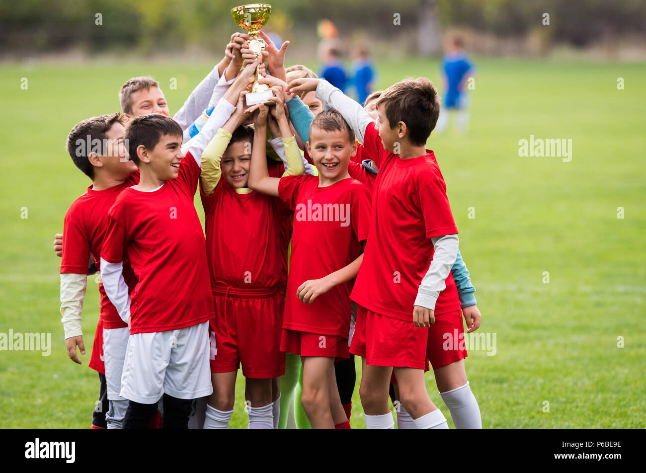 Kids soccer football - young children players celebrating with a trophy ...