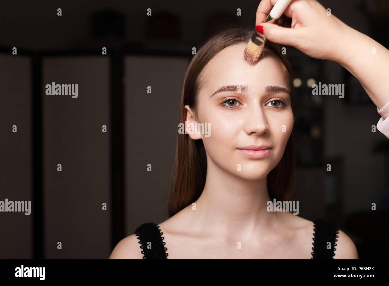 makeup artist applying foundation on a model forehead Stock Photo - Alamy
