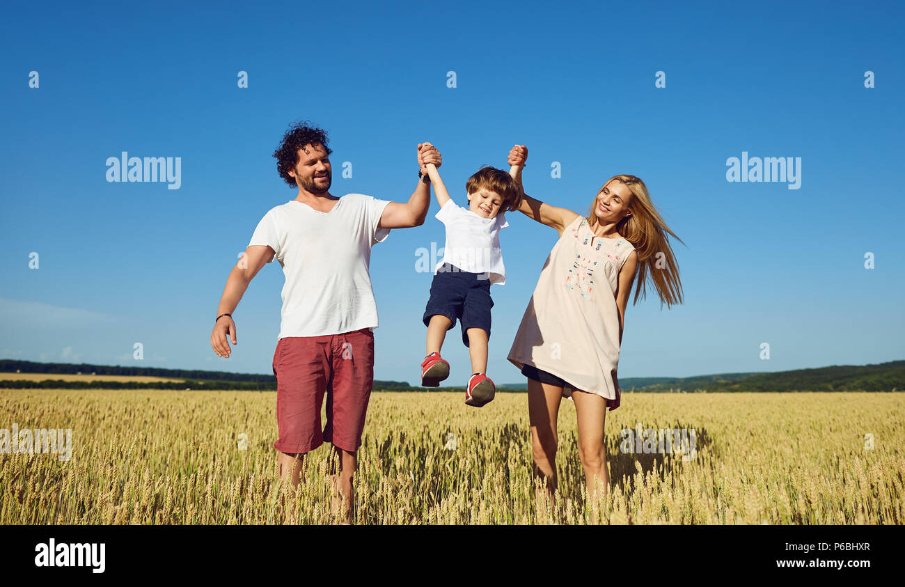 Happy family having fun playing in the field Stock Photo - Alamy