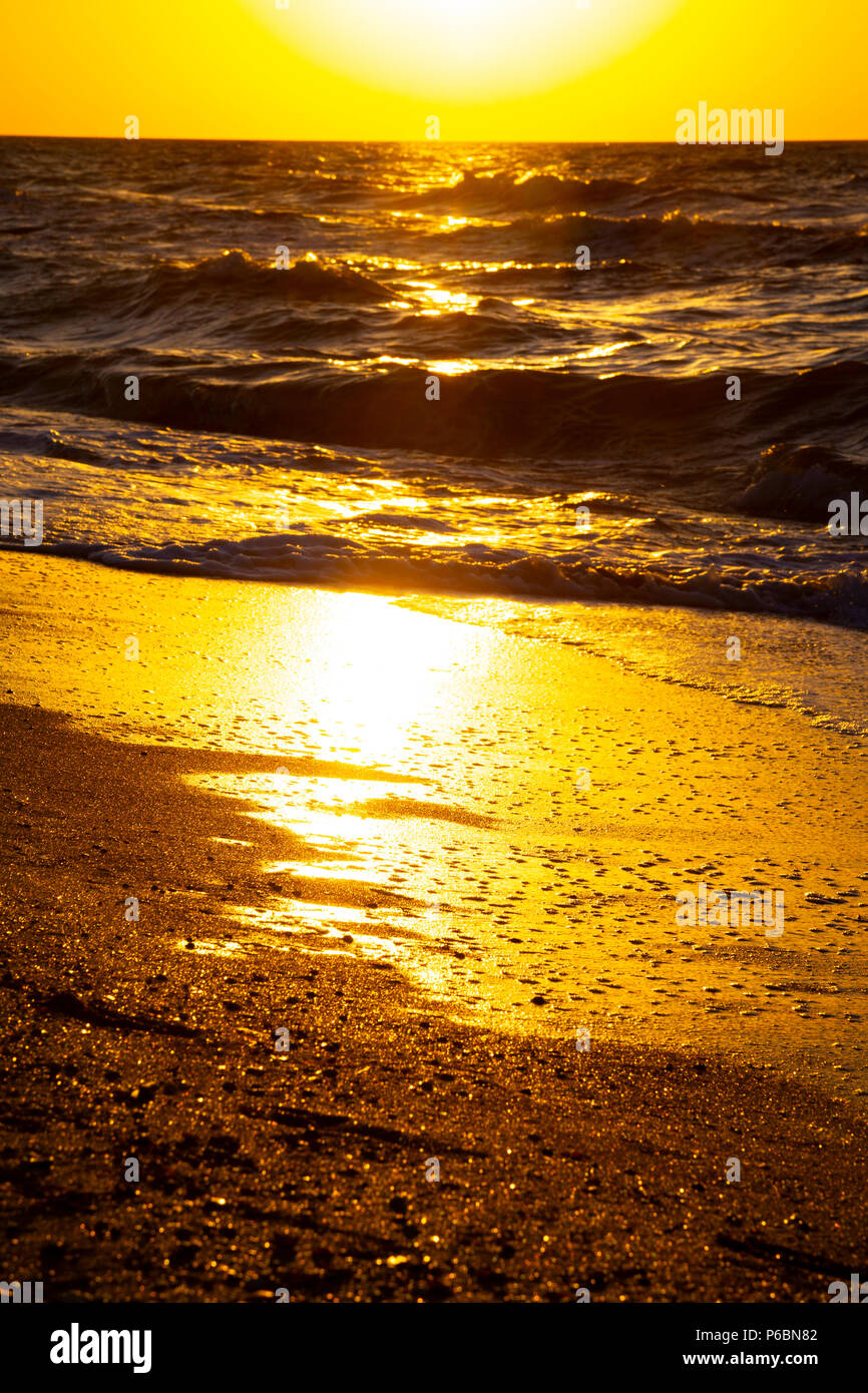 Beautiful sea at sunset. Sandy beach in the background of the yellow ...