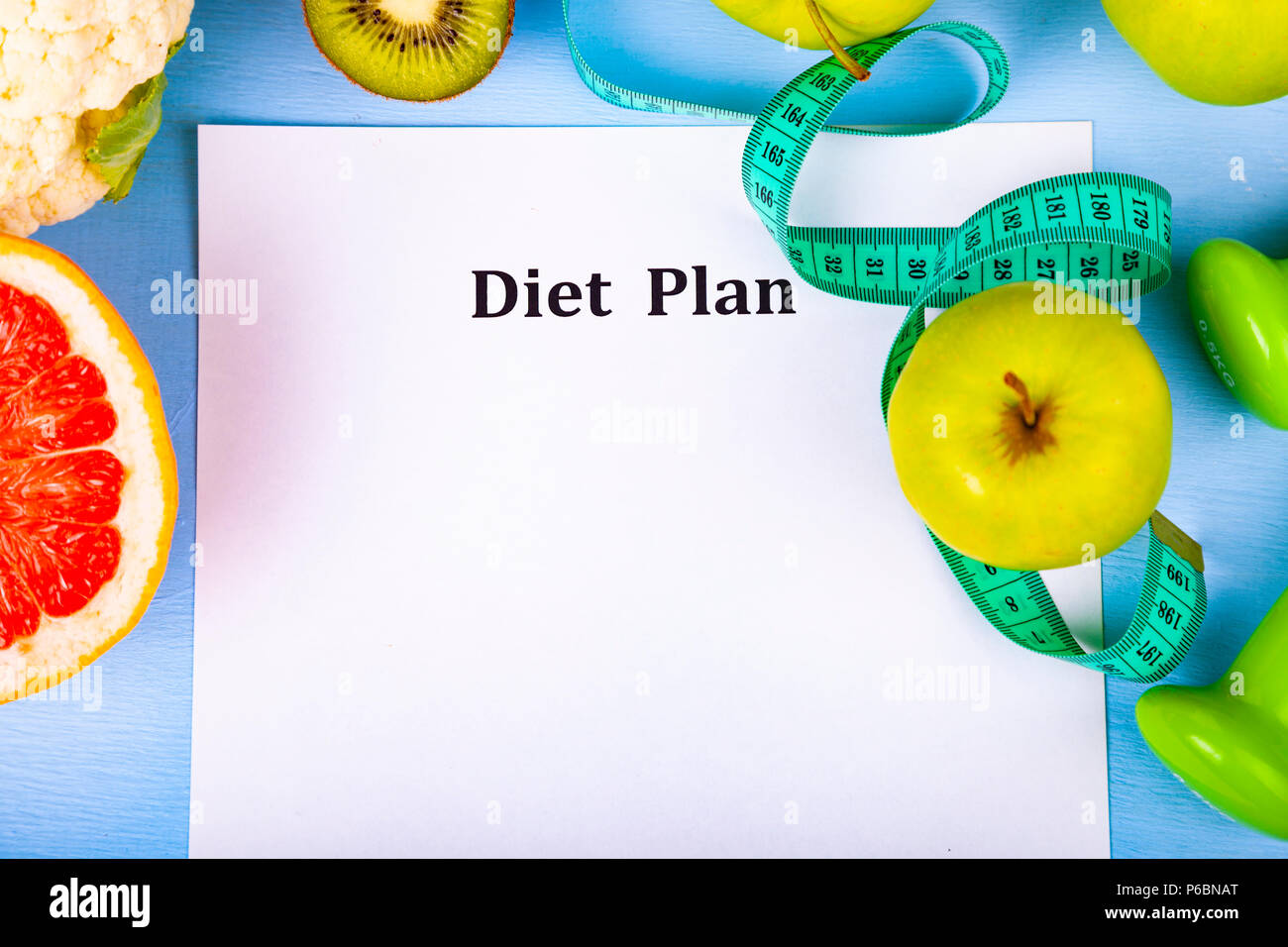 Food and sheet of paper with a diet plan on a blue wooden background ...