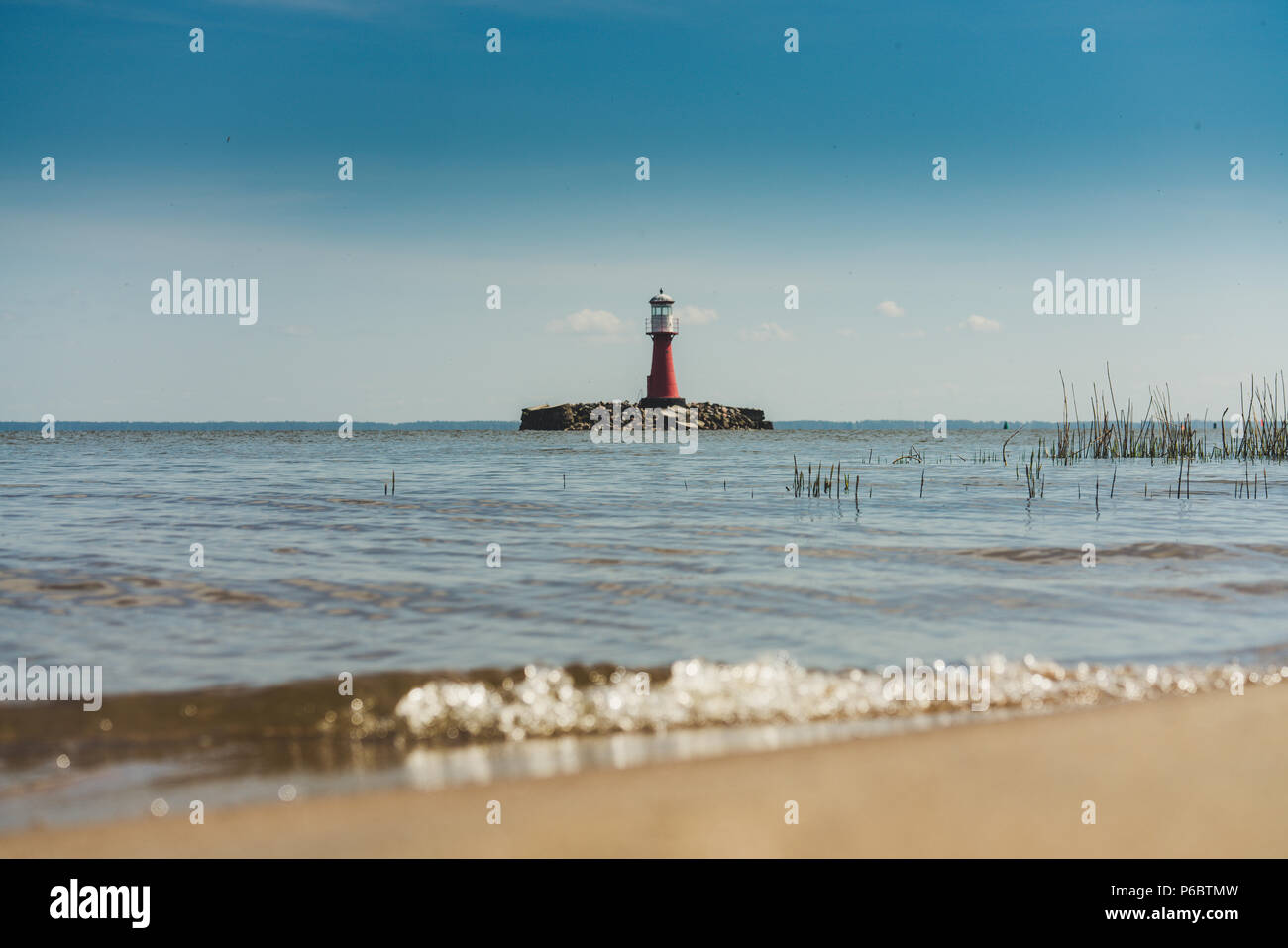 Red lighthouse with a beach in the foreground Stock Photo - Alamy