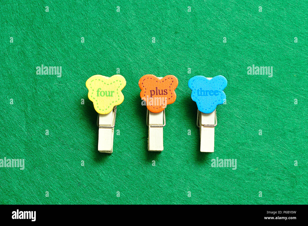 Four plus three on a green background Stock Photo - Alamy