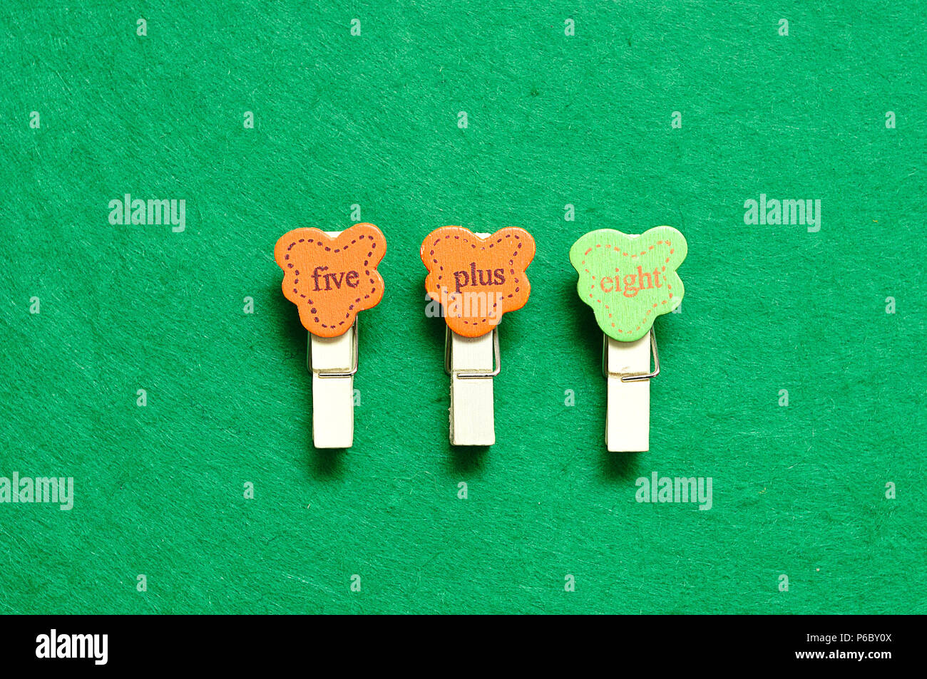 Five plus eight on a green background Stock Photo - Alamy