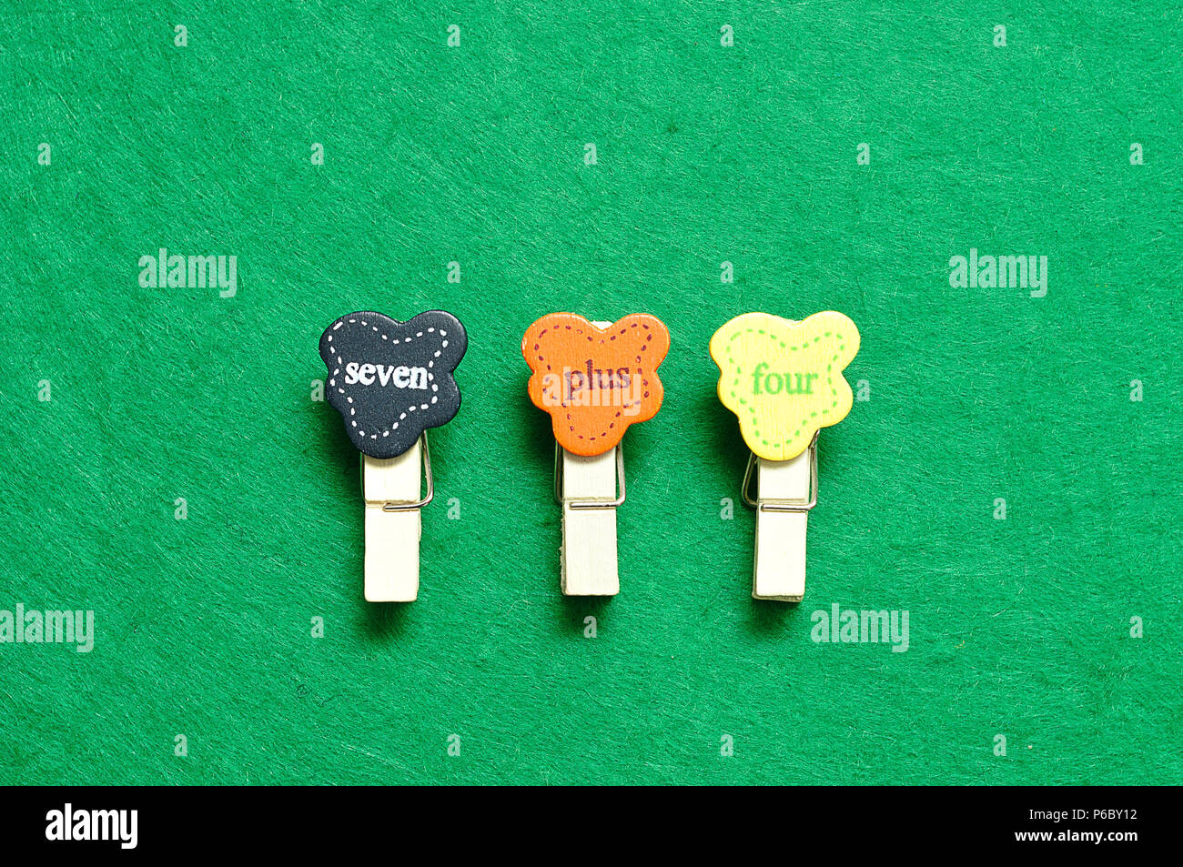 Seven plus four on a green background Stock Photo - Alamy