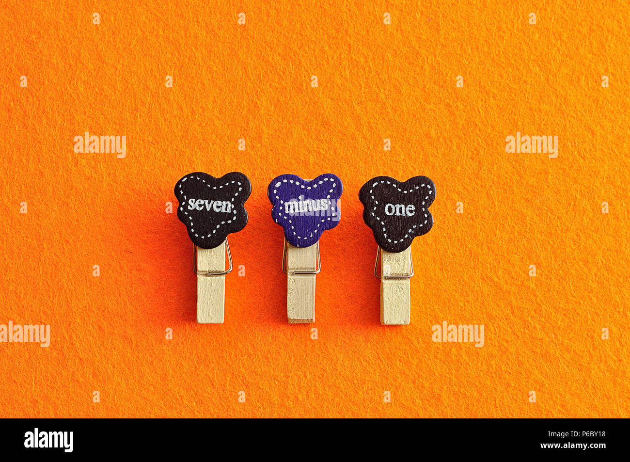 Seven minus one on an orange background Stock Photo - Alamy