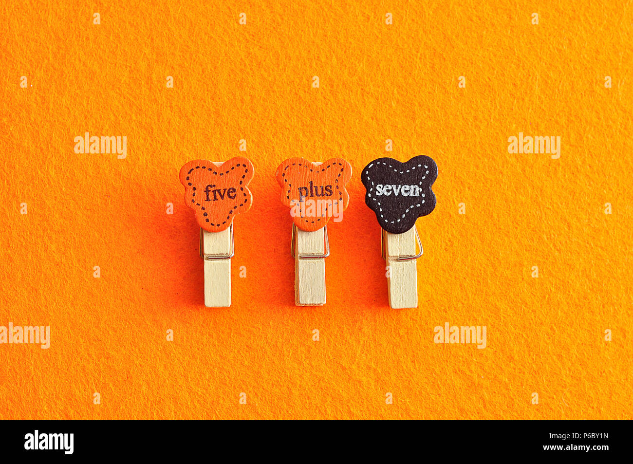 Five plus seven on an orange background Stock Photo - Alamy