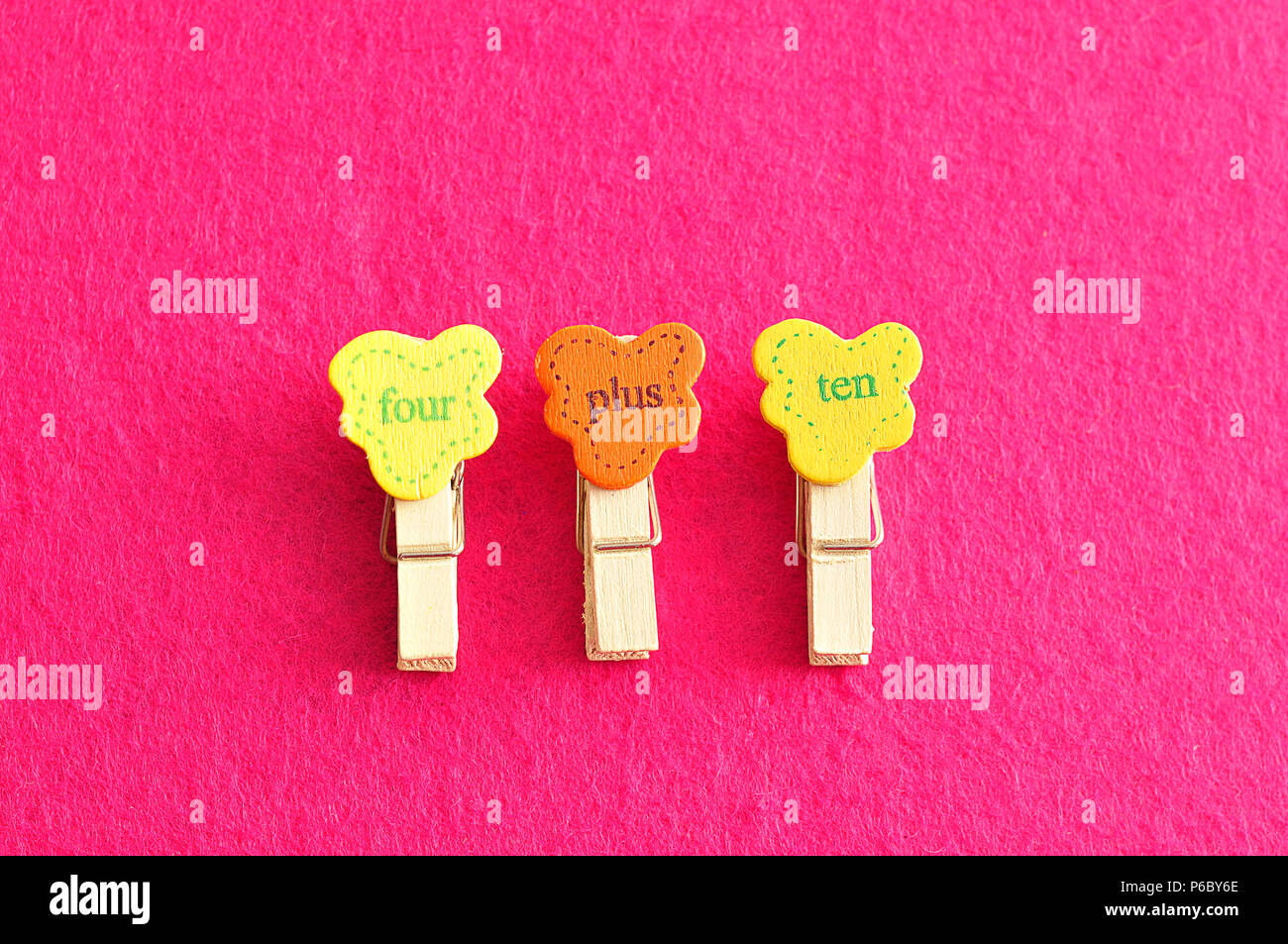 Four plus ten on a pink background Stock Photo - Alamy