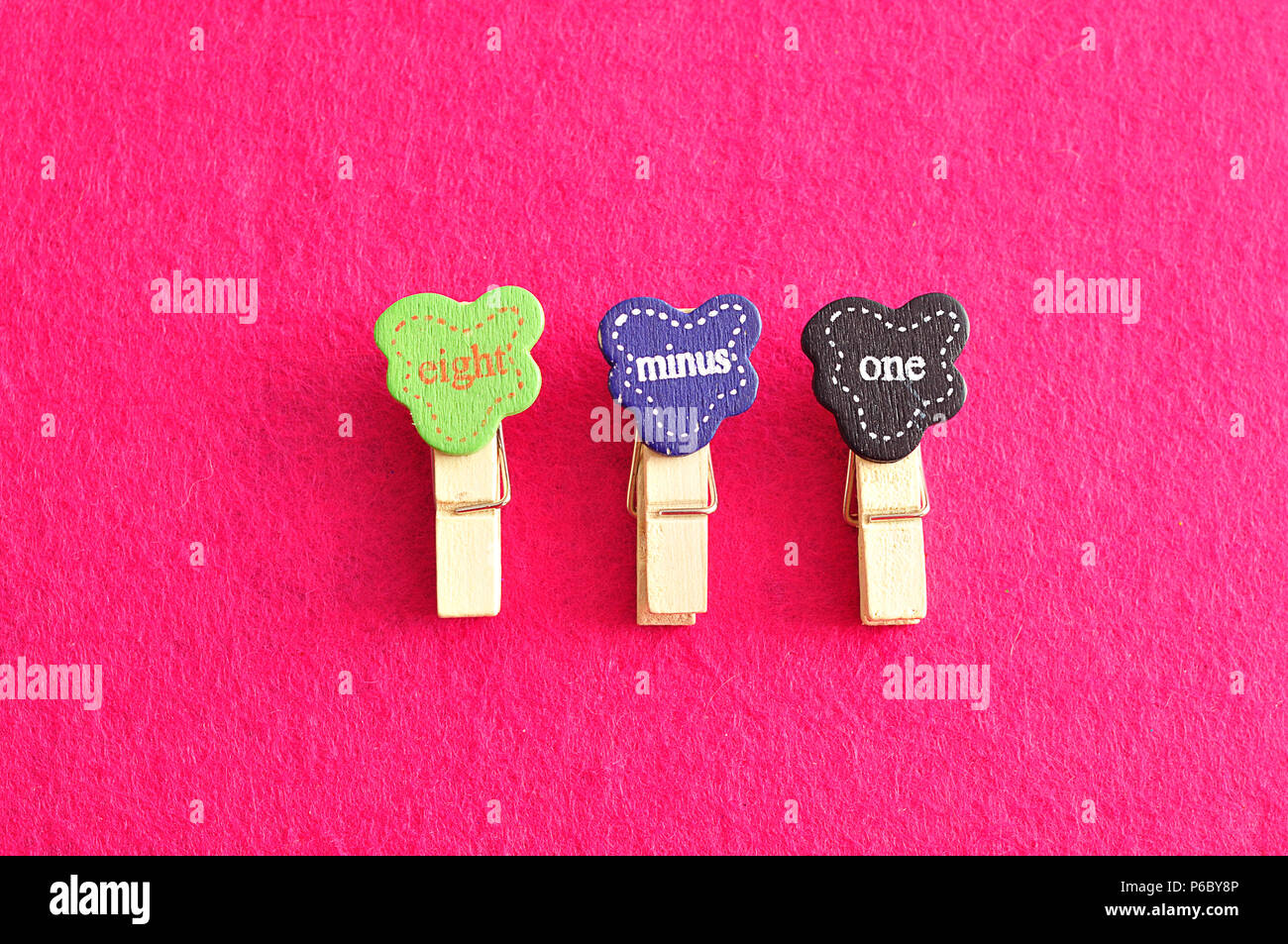 Eight minus one on a pink background Stock Photo - Alamy