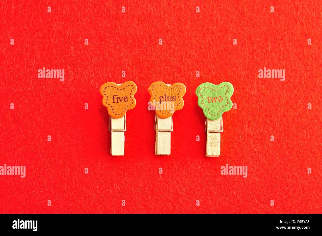 Five plus two on a red background Stock Photo - Alamy