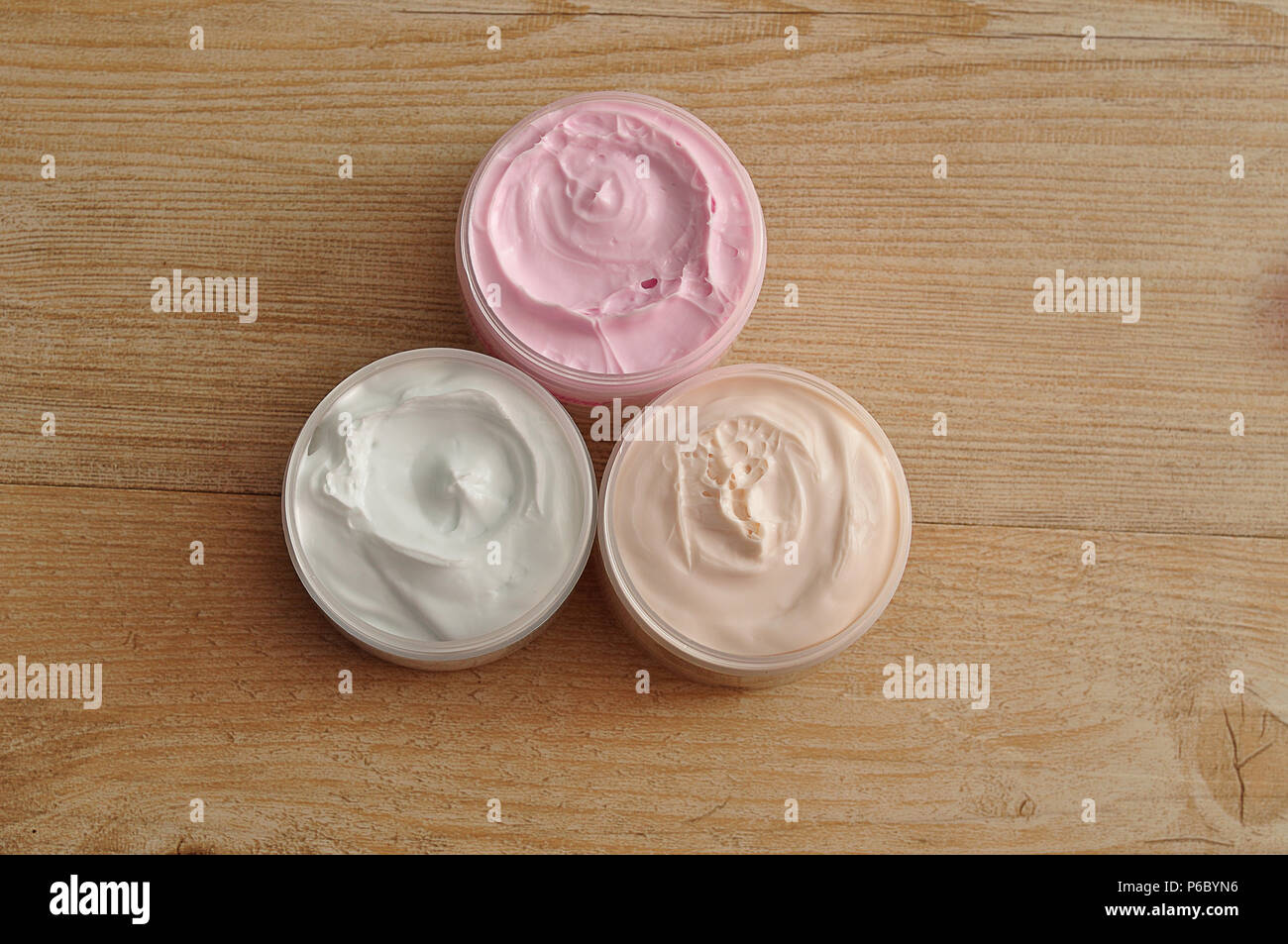 Jars of different color body lotion Stock Photo - Alamy