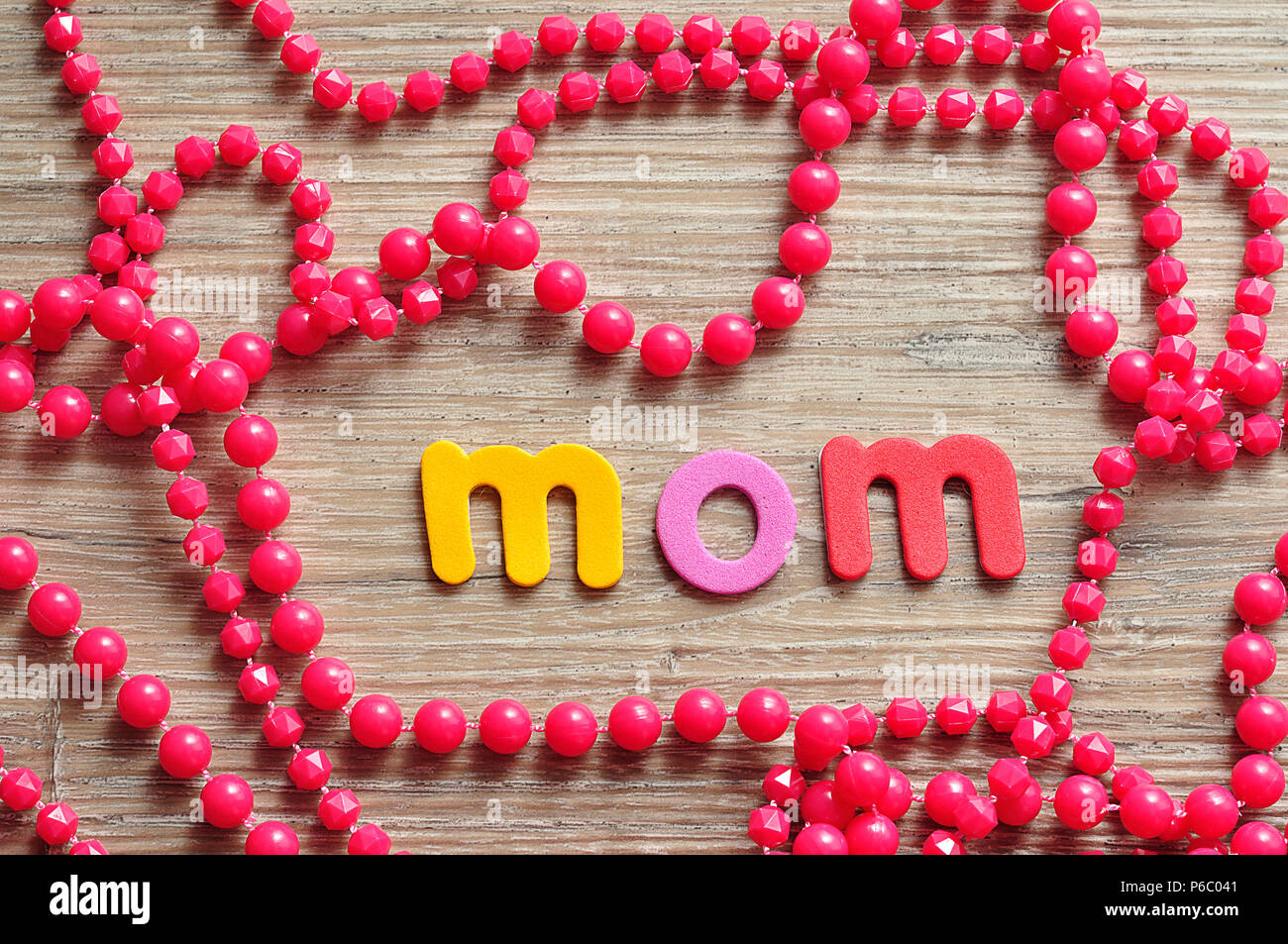 The word mom displayed with a string of pink beads Stock Photo - Alamy