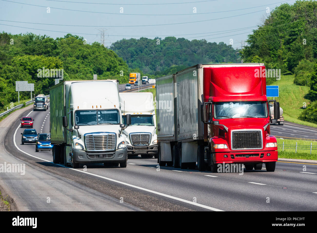 Tractor-trailer trucks lead traffic down the highway. Note: All logos ...