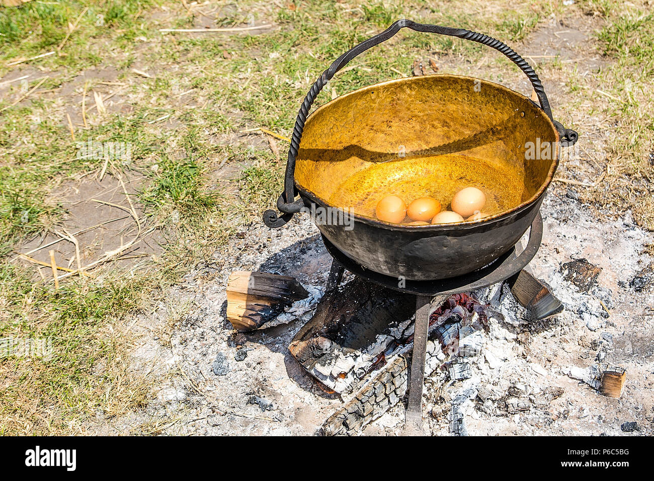 Eggs in old metallic cauldron on camp fire Stock Photo - Alamy