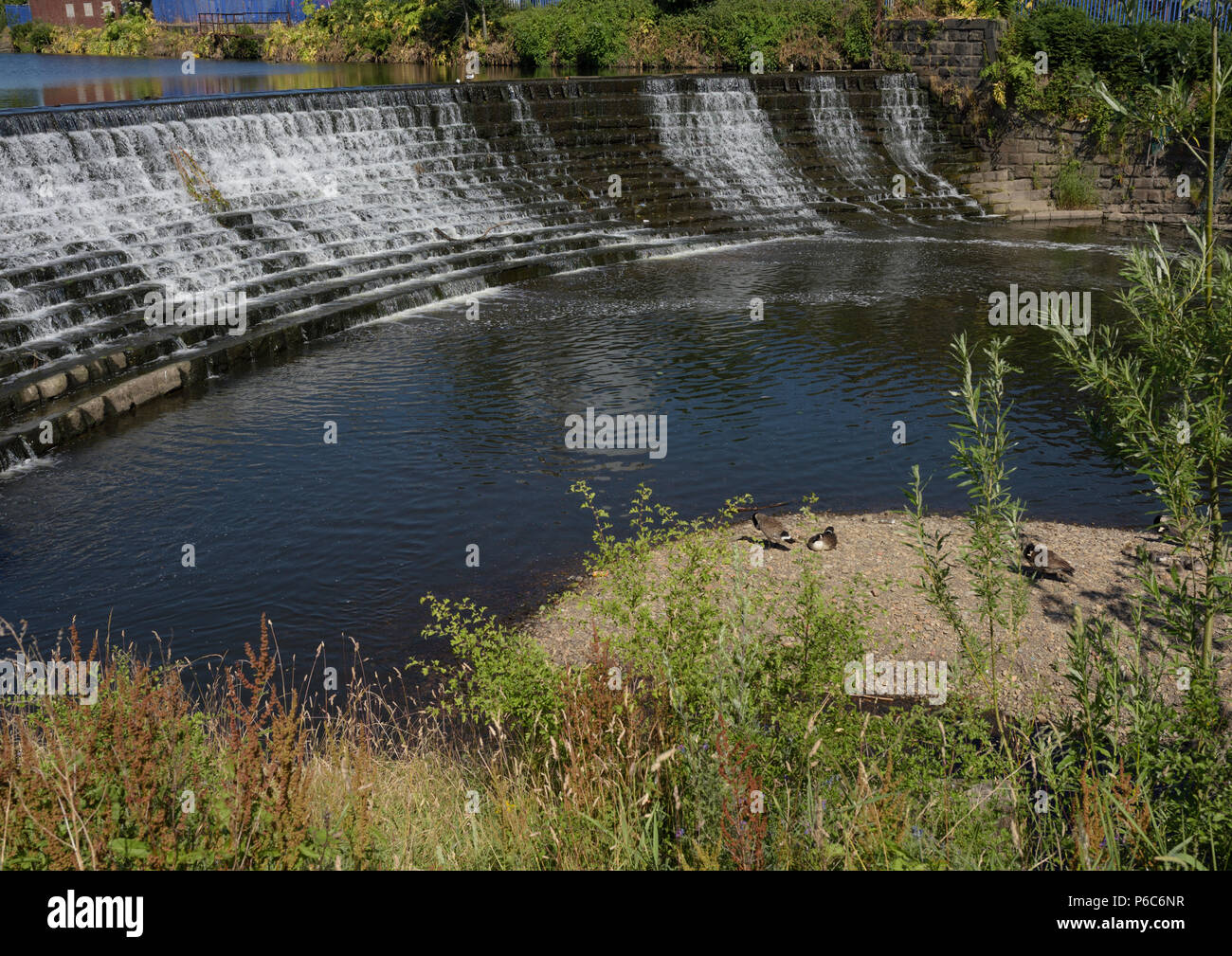 Horseshoe weir with steps, low water flow, gravel shoal in river irwell ...