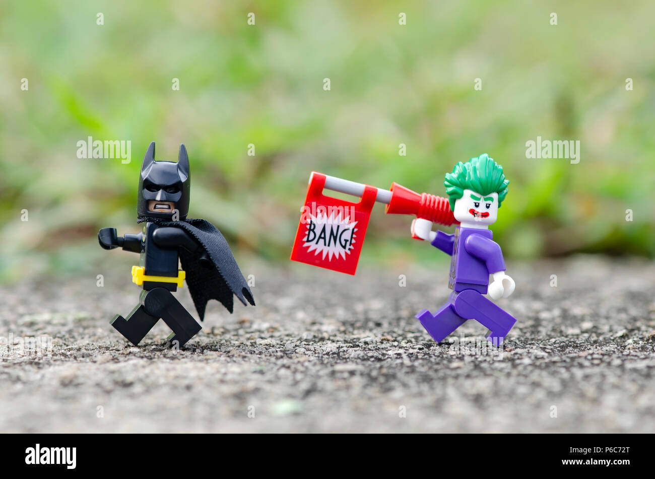 mini figure of Joker with bang gun chasing Batman. Lego minifigures are ...