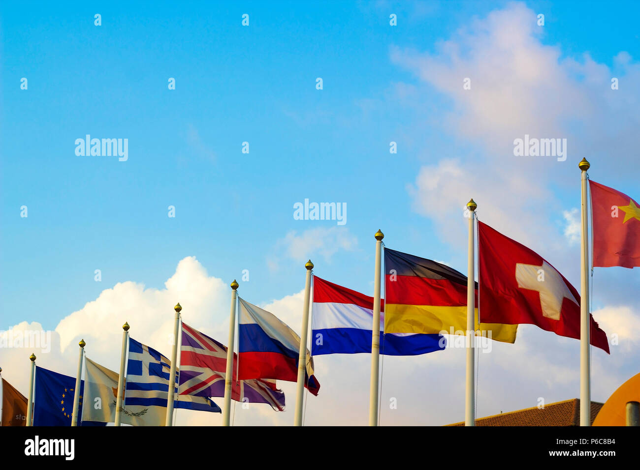 Flags of different countries flapping in wind against blue sky Stock ...