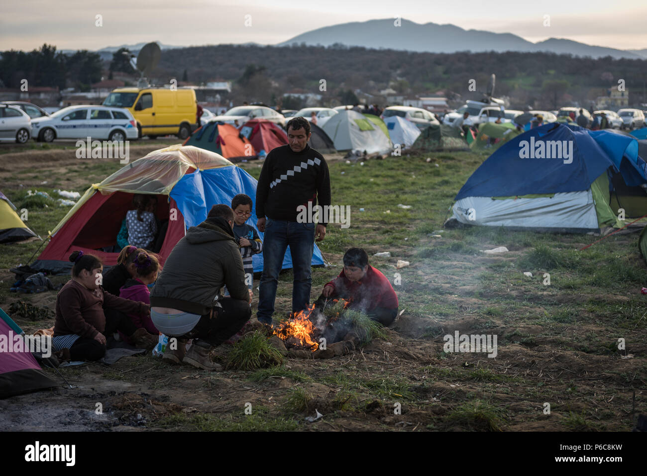 The family sitting by the bonfire at the makeshift refugee camp of the ...