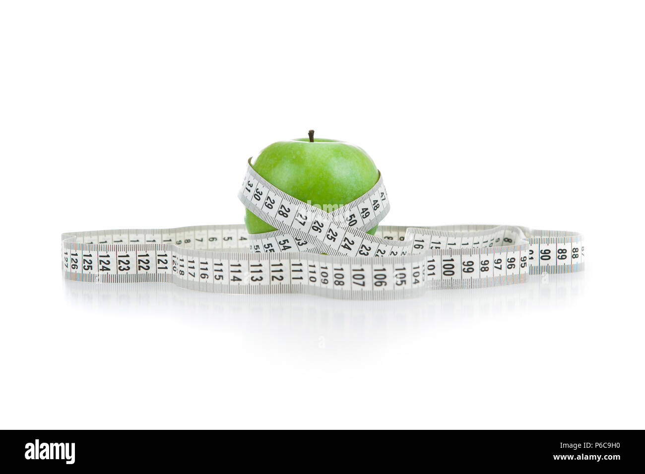 green apple with a ruler on a white background Stock Photo - Alamy