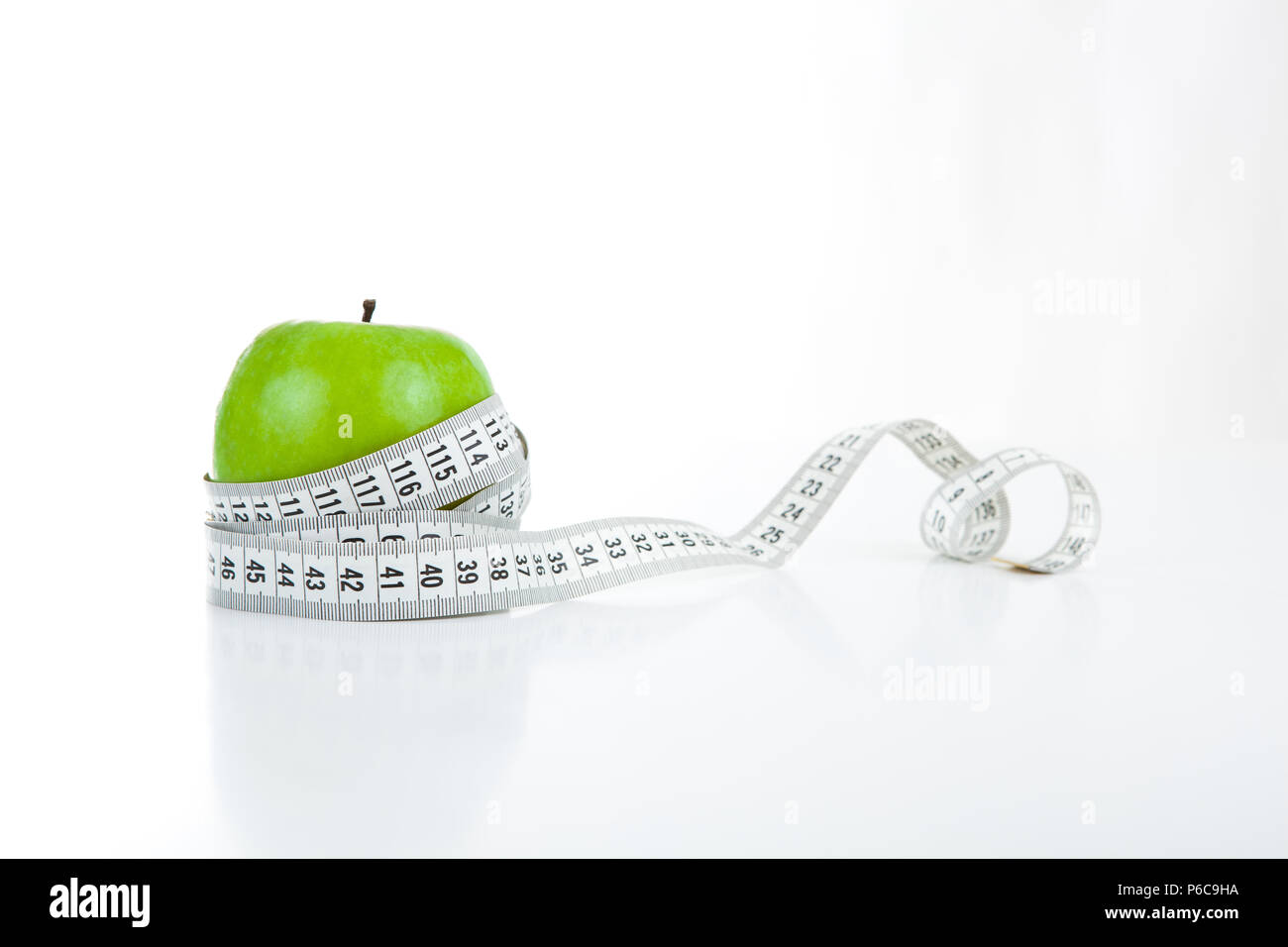 green apple with a ruler on a white background Stock Photo - Alamy