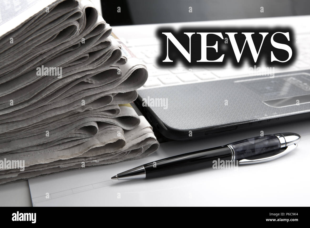 stack of newspapers and keyboard close-up on white Stock Photo - Alamy