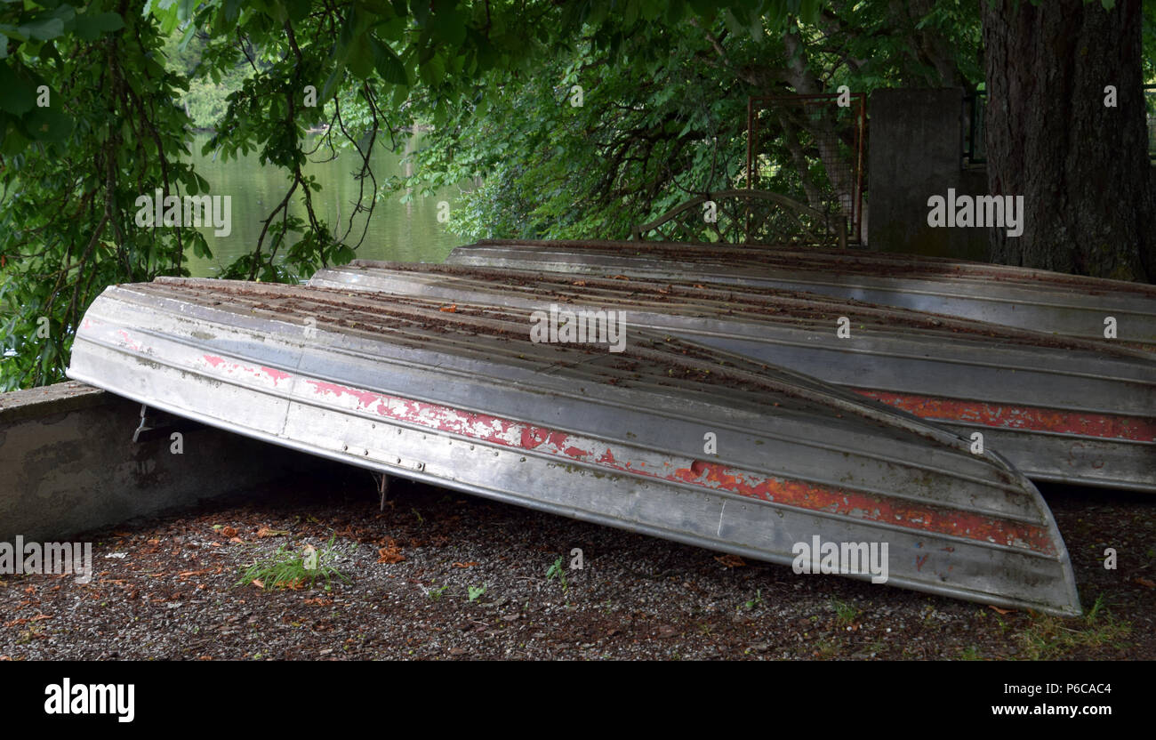 neglected old and rotten row boat lying upside down made of metal and ...