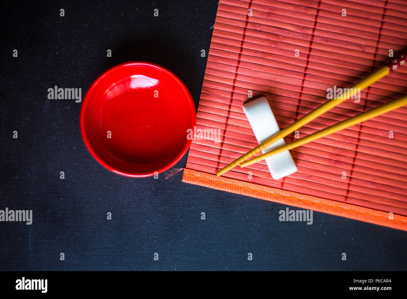 Table setting in red color for asian cuisine dinner with chopsticks ...