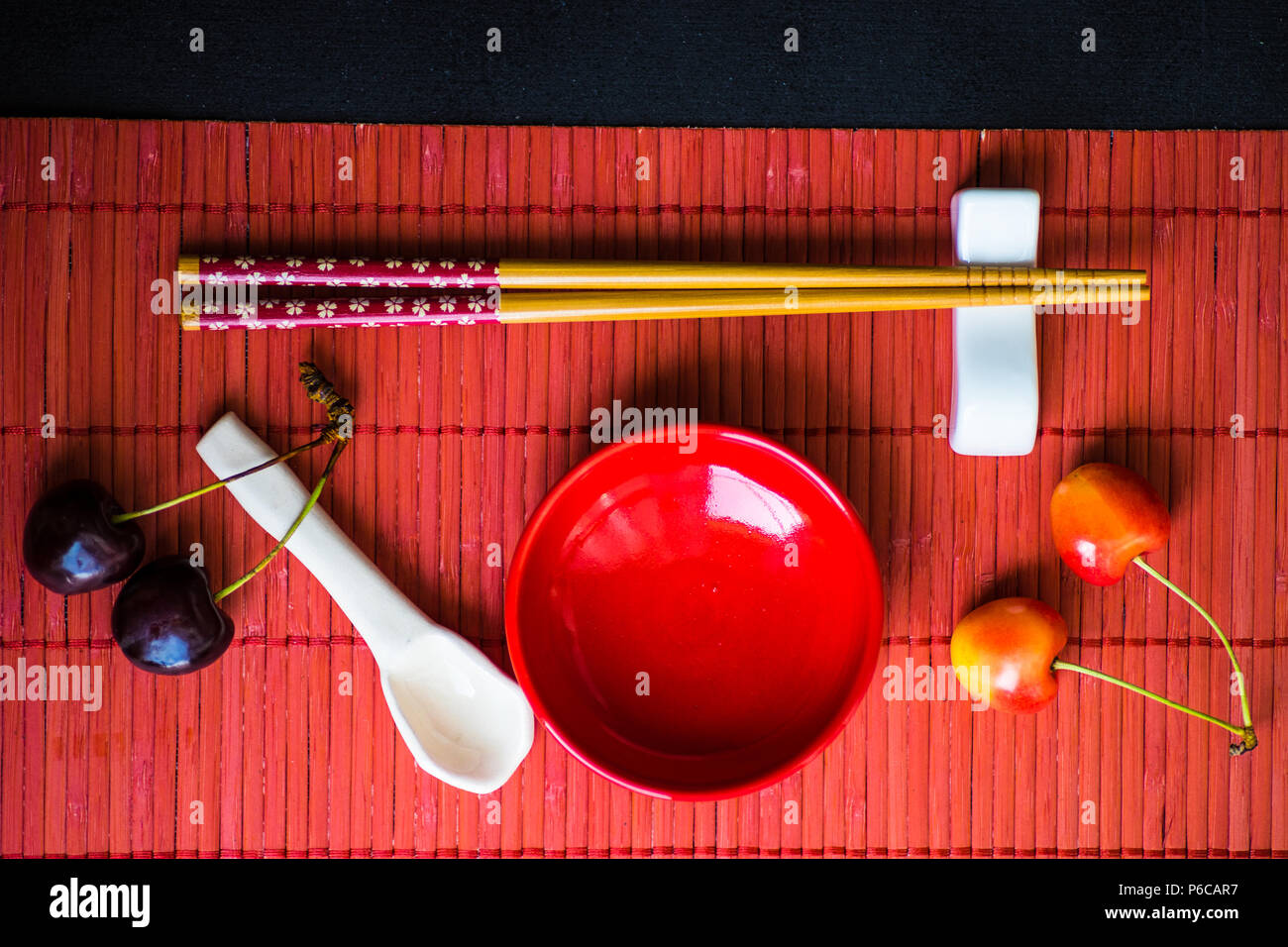 Table setting in red color for asian cuisine dinner with chopsticks ...