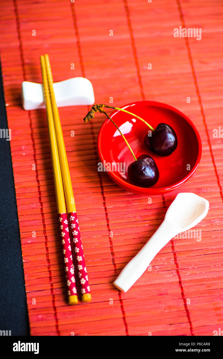 Table setting in red color for asian cuisine dinner with chopsticks ...