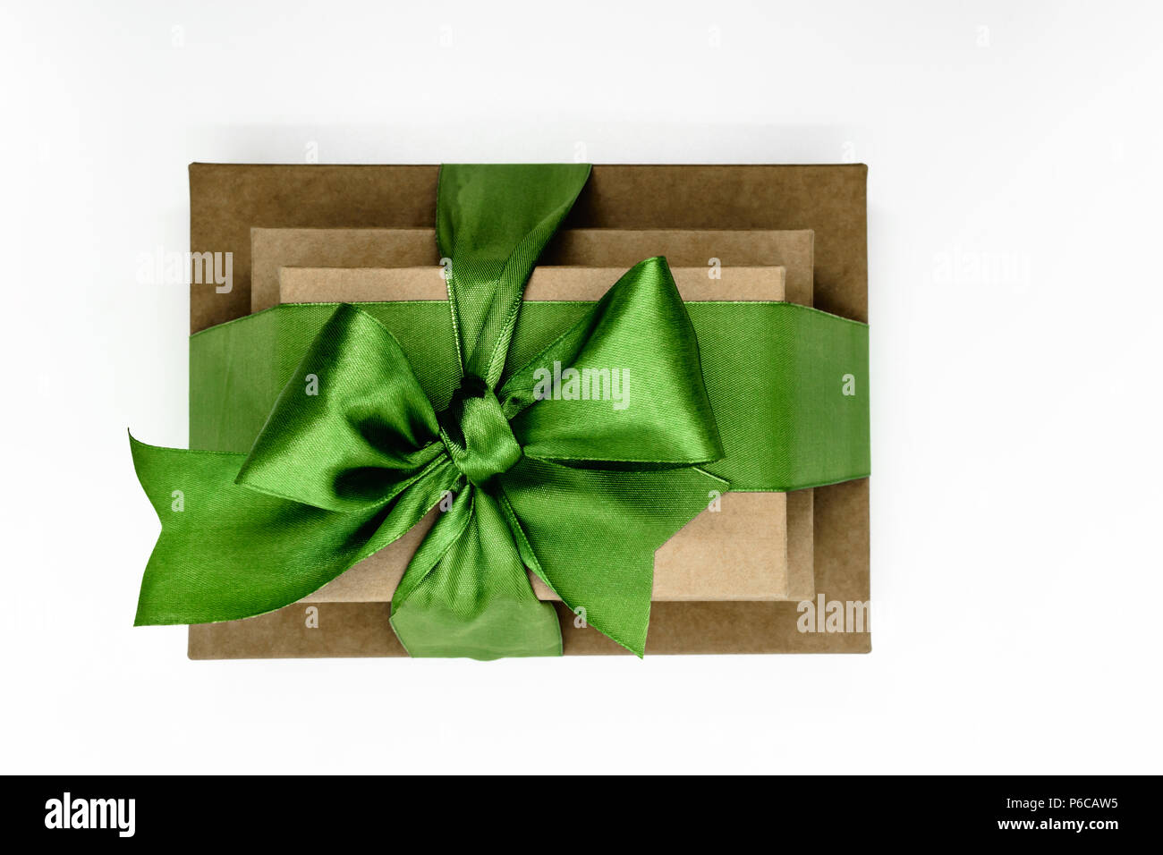 Three brown carton gift boxes bundled with green ribbon isolated on ...