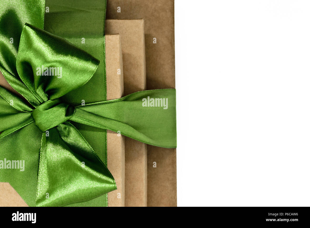 Three brown carton gift boxes bundled with green ribbon isolated on ...