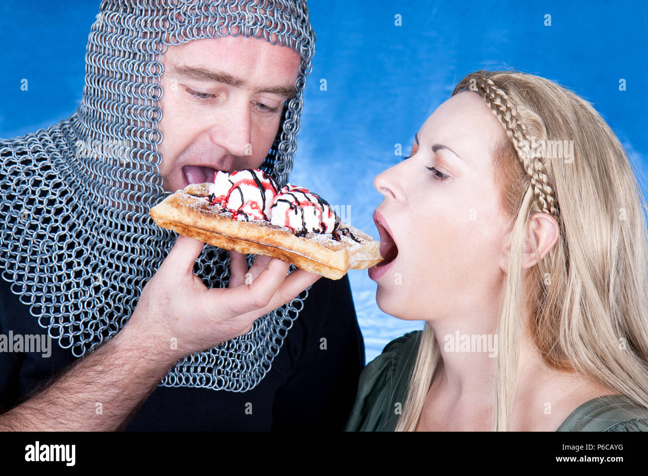 Knight and princes eating waffle with ice-cream , studio shot Stock ...