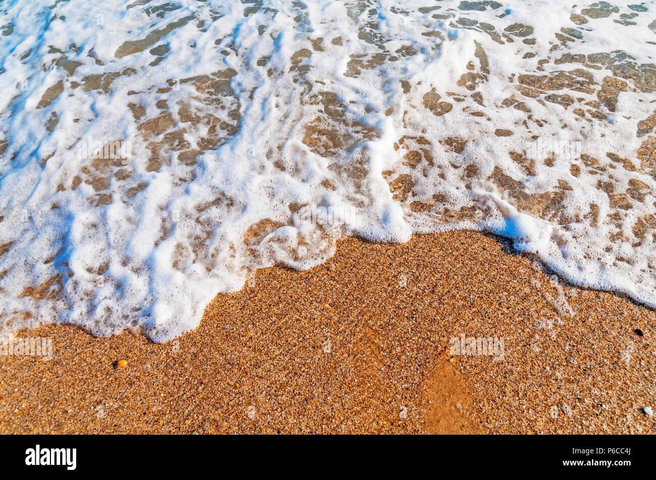Tropical sand beach with wave and burning sun Stock Photo - Alamy