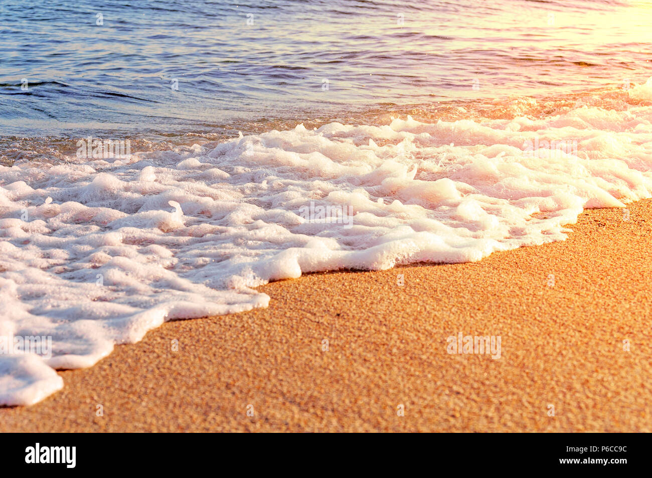 Tropical sand beach with wave and burning sun Stock Photo - Alamy