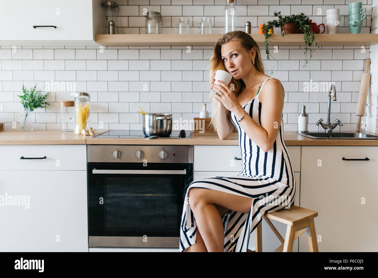 Photo of beautiful woman in long striped dress in kitchen Stock Photo ...