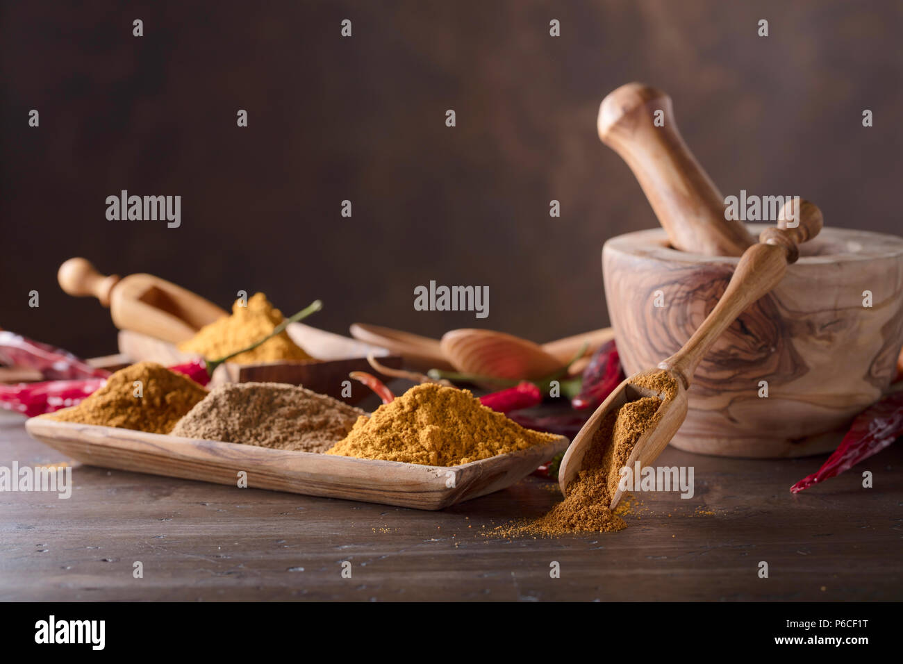 Various Indian spices with wooden spoons on a old wooden table, copy ...