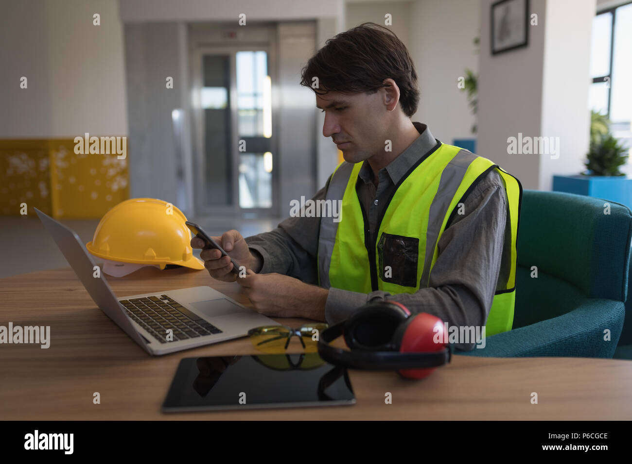 Male worker using mobile phone at desk Stock Photo - Alamy