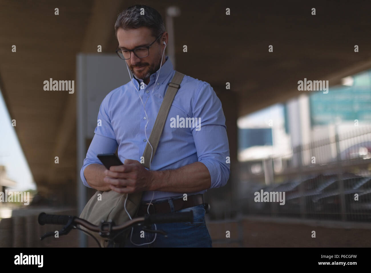 Man using mobile phone under bridge Stock Photo - Alamy