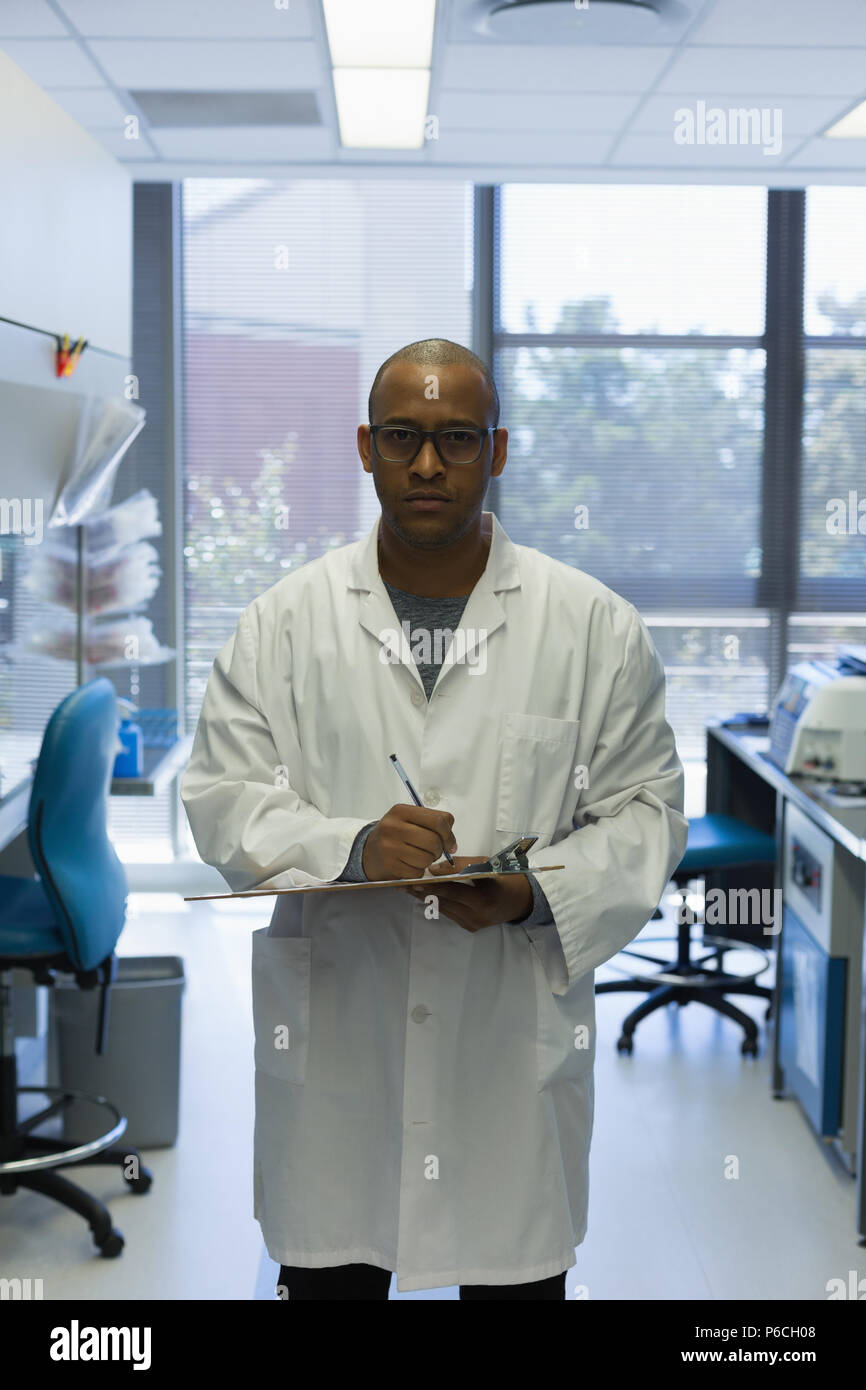 Male scientist with clipboard standing in lab Stock Photo - Alamy