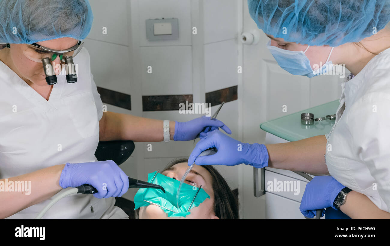 Woman at dentist clinic gets dental treatment to fill a cavity in a ...
