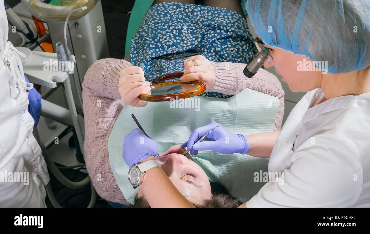 Woman at dentist clinic gets dental treatment to fill a cavity in a ...