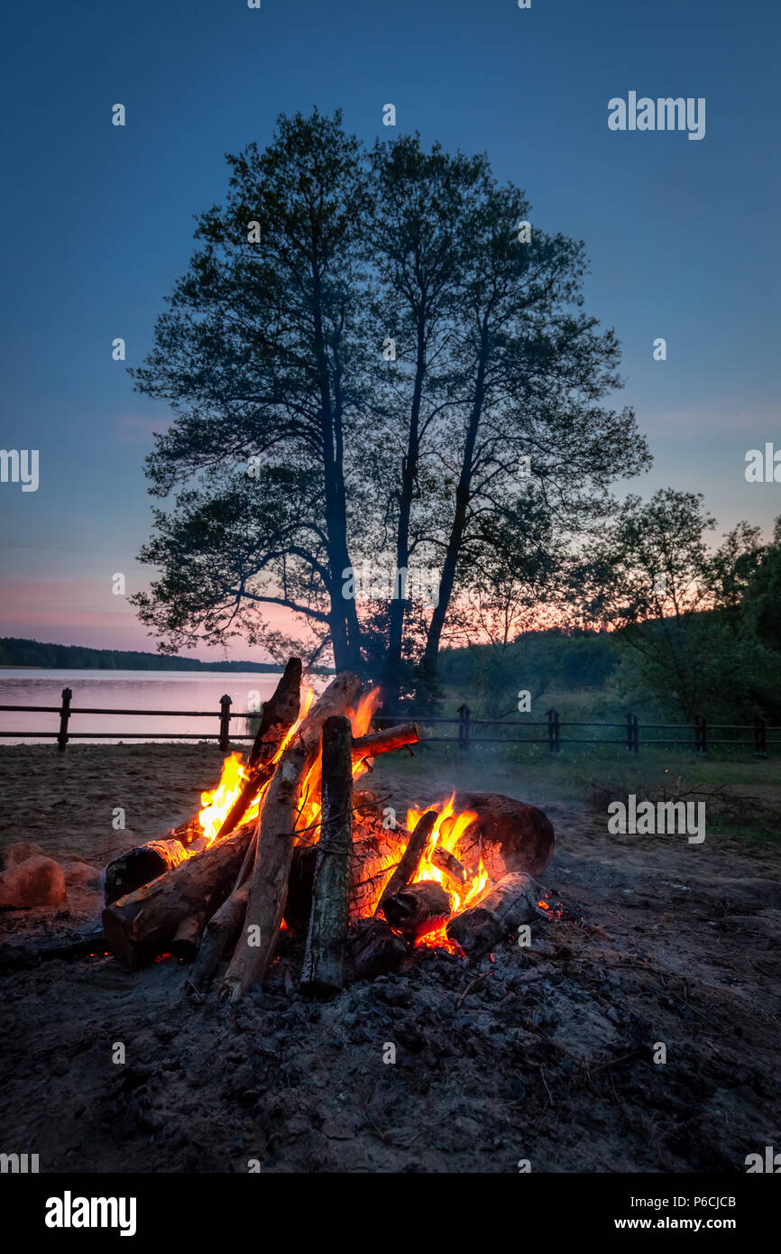 Amazing bonfire at dusk by the lake in summer Stock Photo - Alamy